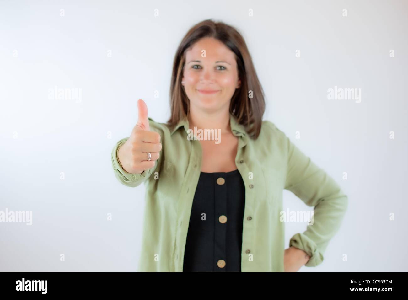 Beautiful young woman in green blouse making finger up gesture Stock ...
