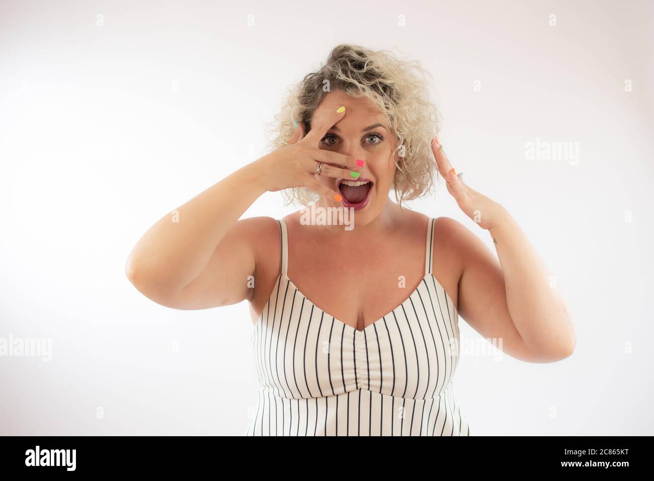 Blonde young woman making funny hand gestures Stock Photo - Alamy
