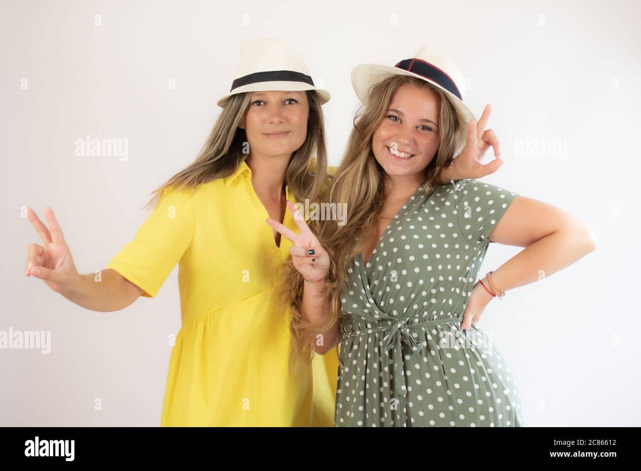 Two smiling girls in hat with cheerful gesture Stock Photo - Alamy