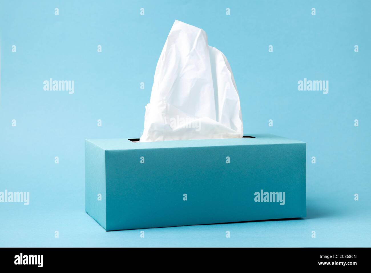 Light blue tissue box on blue background. Cold and flu concept. Minimal ...