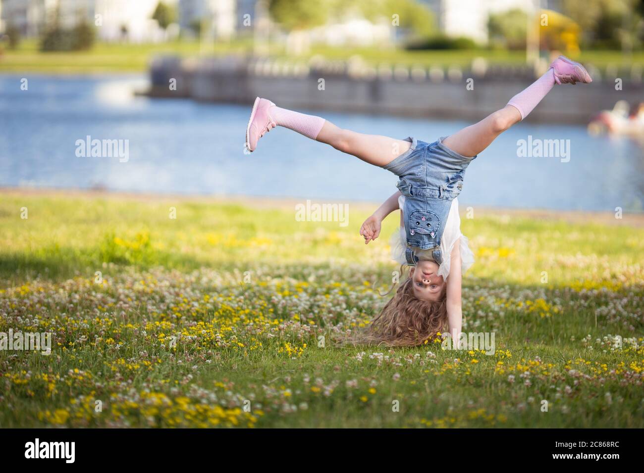 Blonde girl dancing, jumping, doing acrobatics and posing, in a city ...