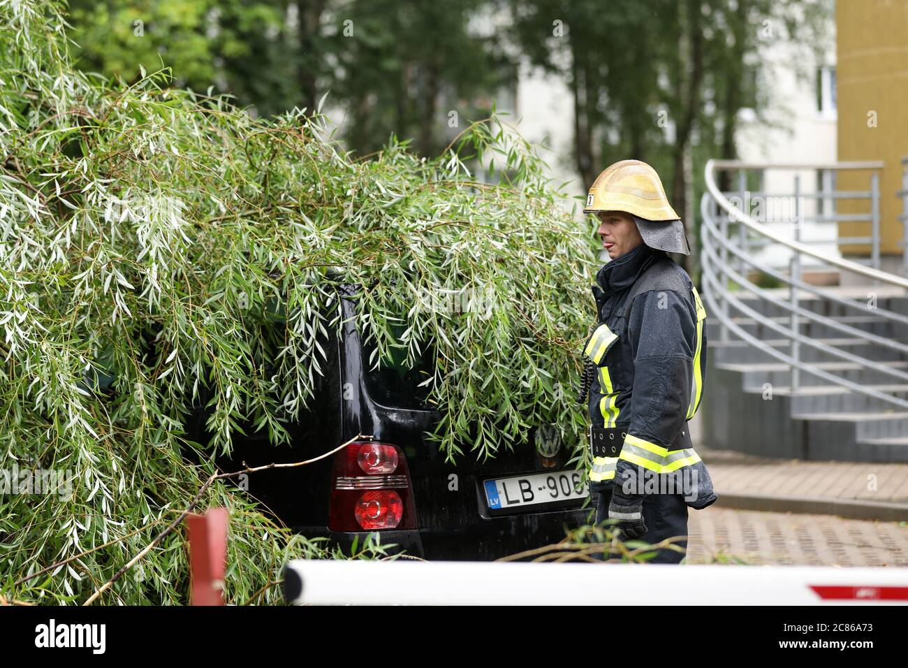 firefighters and police officer help clean up the effects of a fallen ...