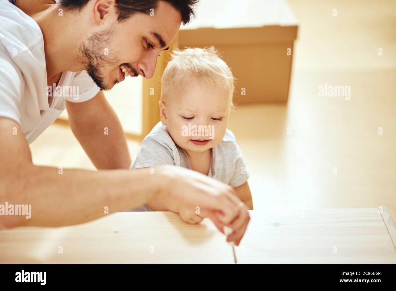 Father and son assembling furniture. Boy helping his dad at home. Happy ...