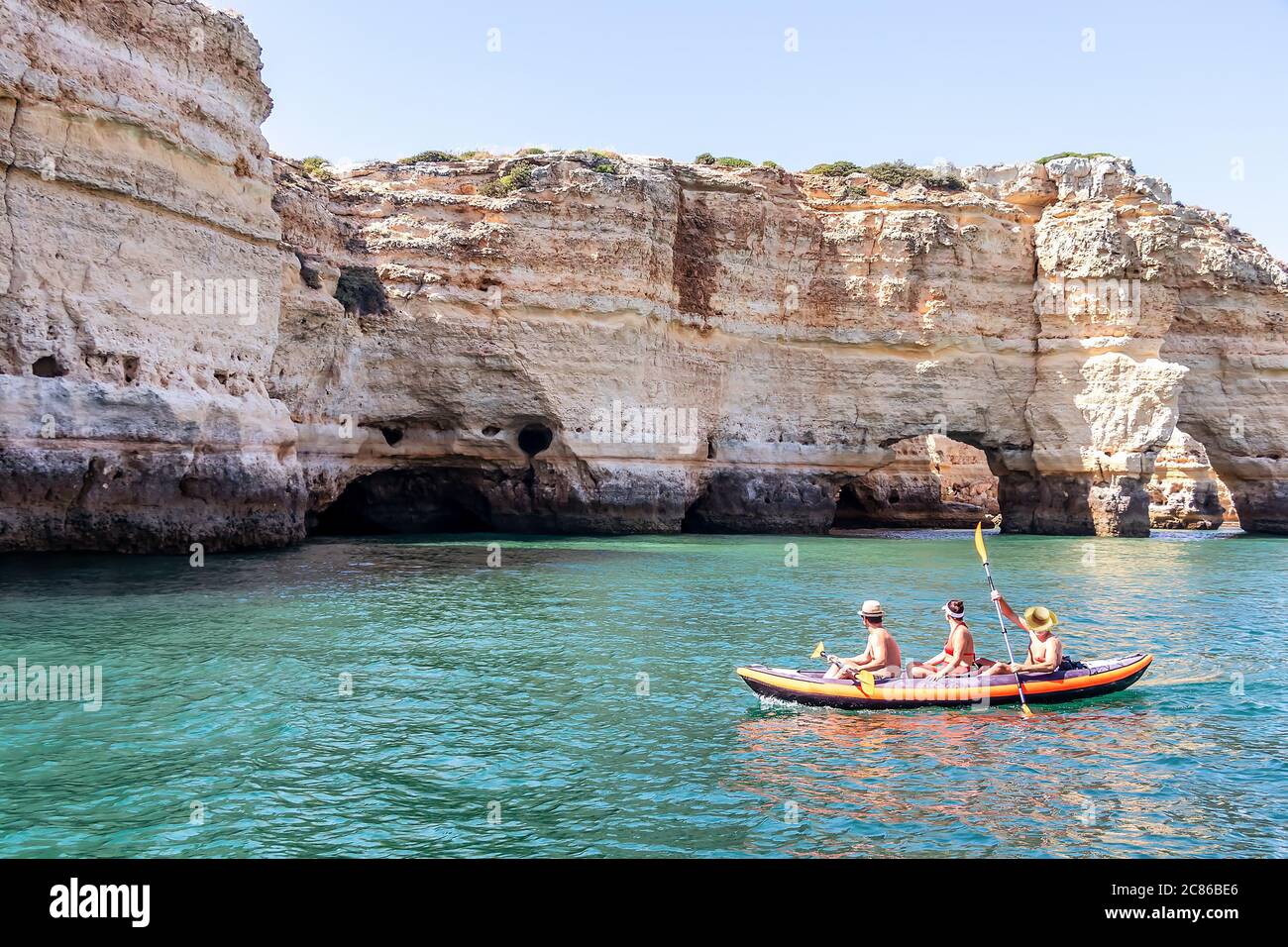 People in a kayak in benagil caves over turquoise waters Stock Photo ...