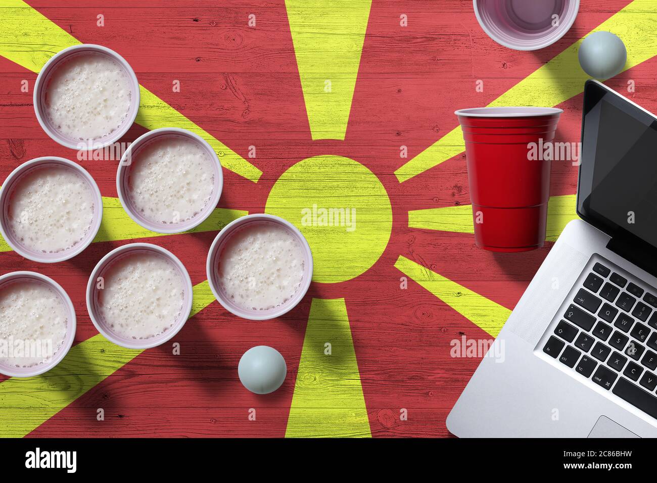 Macedonia flag concept with plastic beer pong cups and laptop on ...
