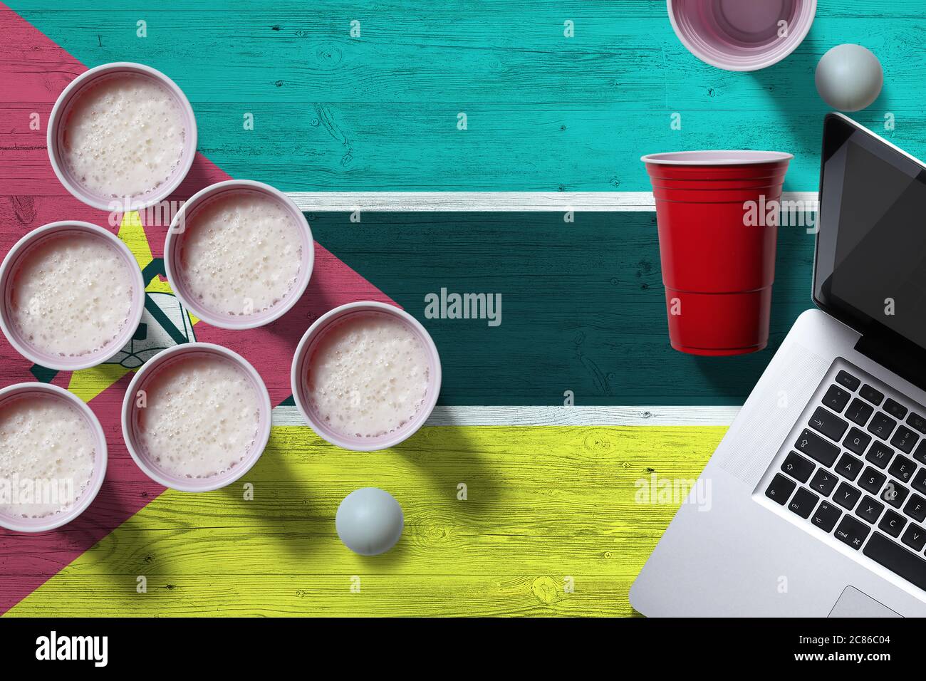 Mozambique Flag Concept With Plastic Beer Pong Cups And Laptop On National Wooden Table Top