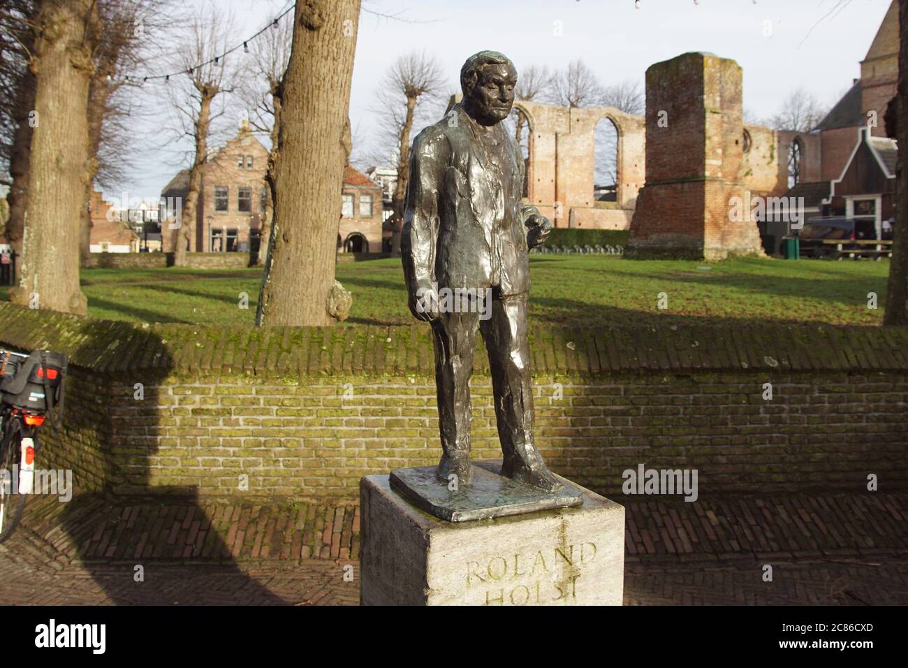 bronze statue of Roland Holst (1888-1976) in front of the ruins of the ...