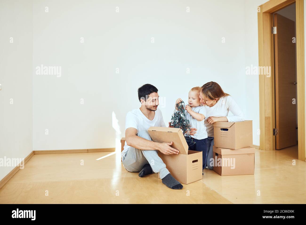 Family, parents and son, unpacking boxes and moving into new home, baby ...