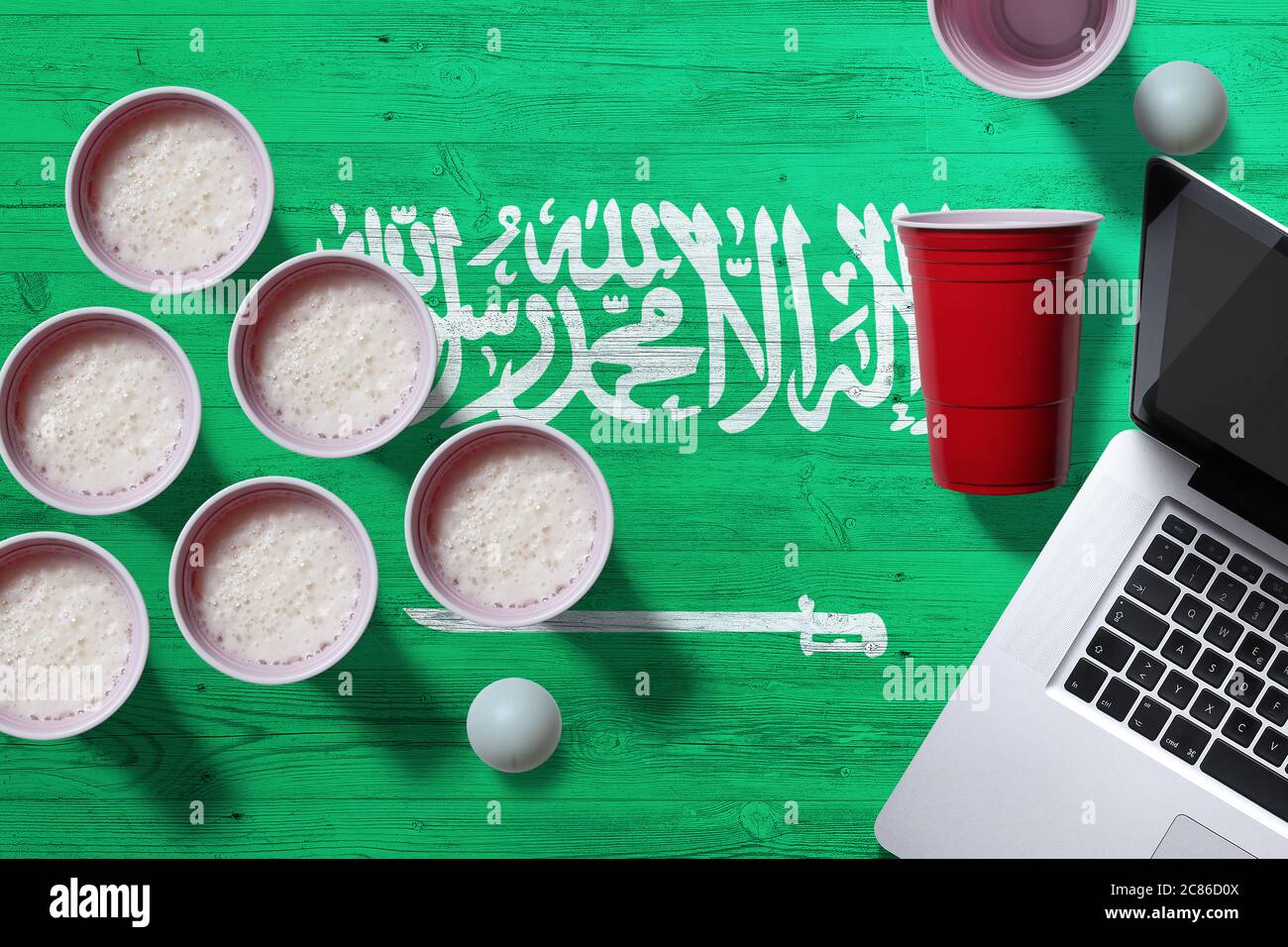 Saudi Arabia flag concept with plastic beer pong cups and laptop on ...