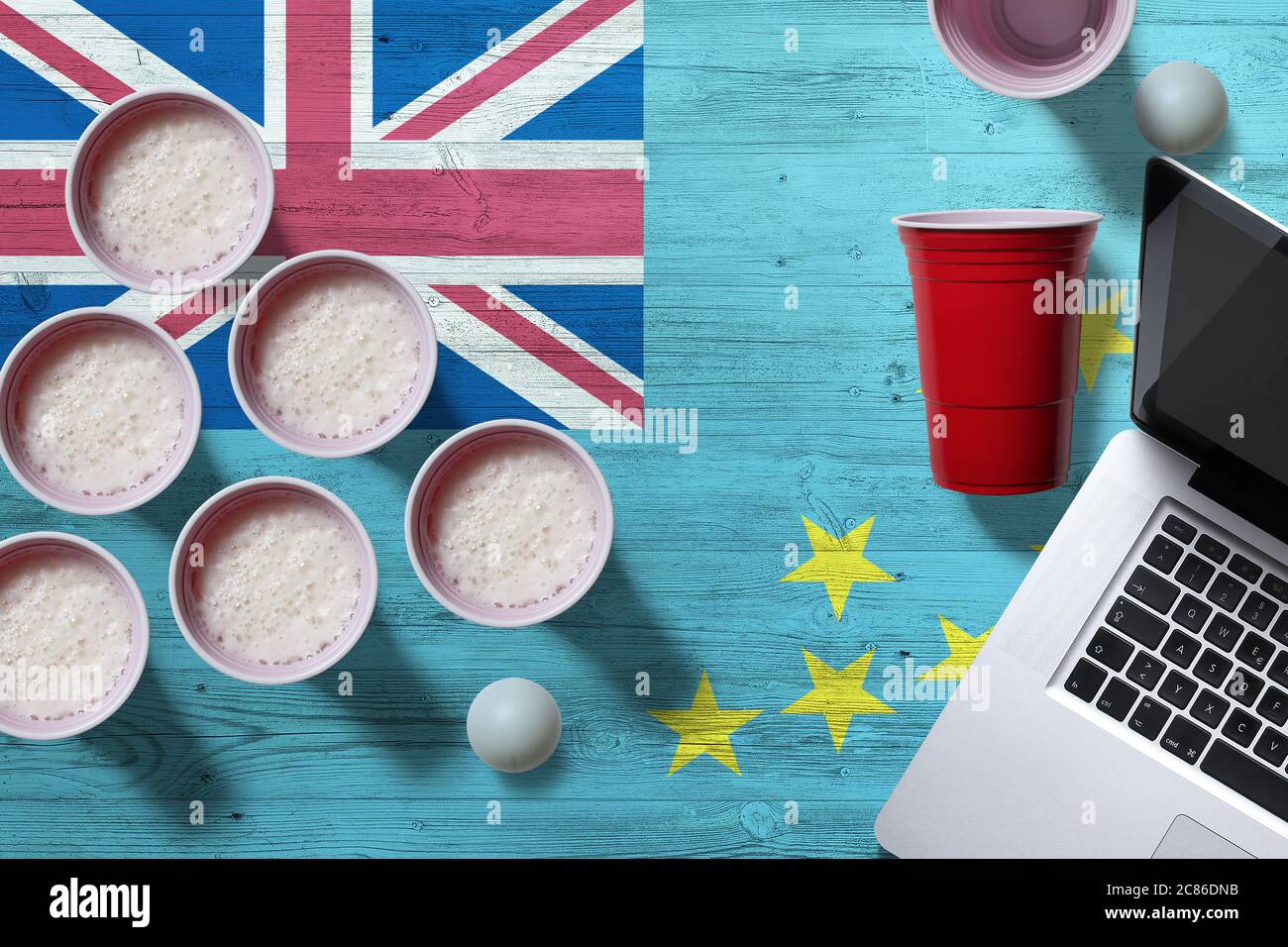 Tuvalu flag concept with plastic beer pong cups and laptop on national ...