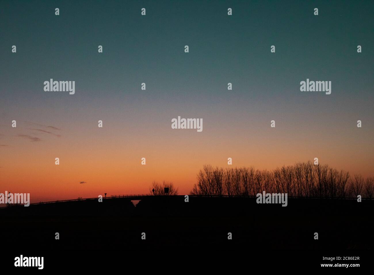 Landscape showing the silhouette of a line of trees with a color ...