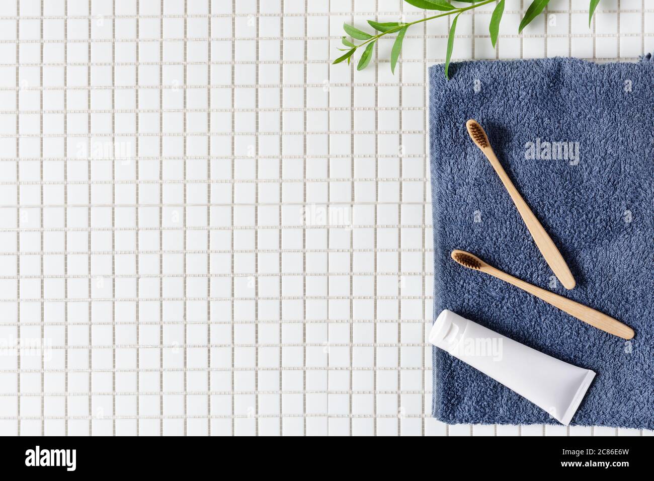 Bamboo toothbrush, toothpaste and towel on white mosaic background top ...
