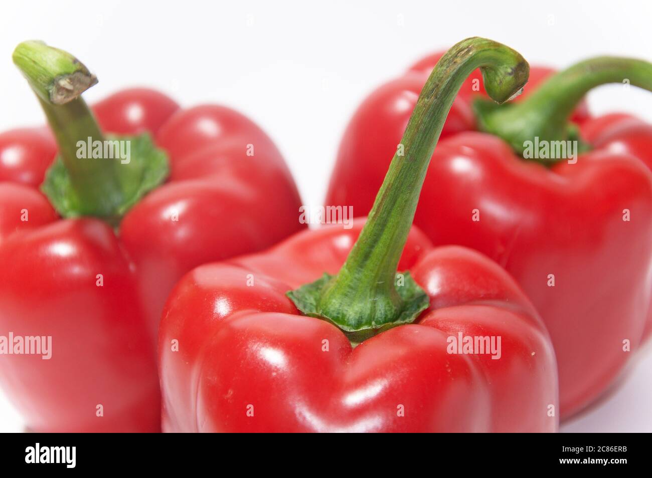 three red paprikas closeup on white background Stock Photo - Alamy