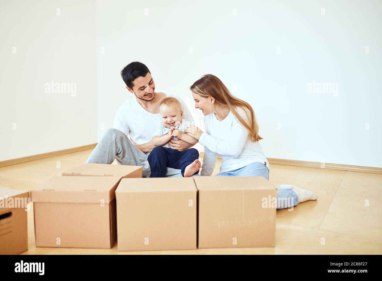 Family, parents and son, unpacking boxes and moving into new home, baby ...