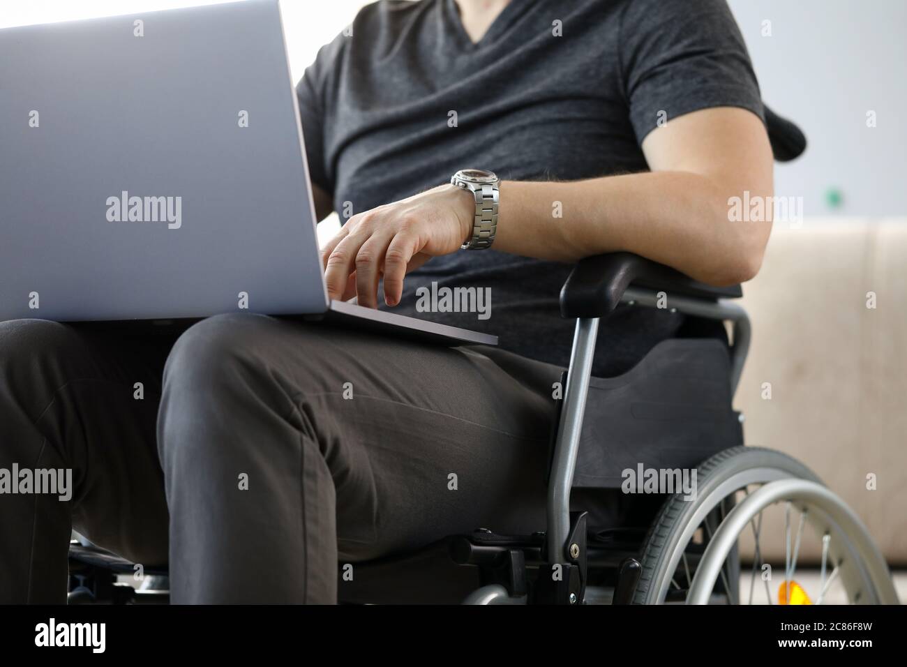Man sitting in wheelchair working with laptop computer Stock Photo - Alamy