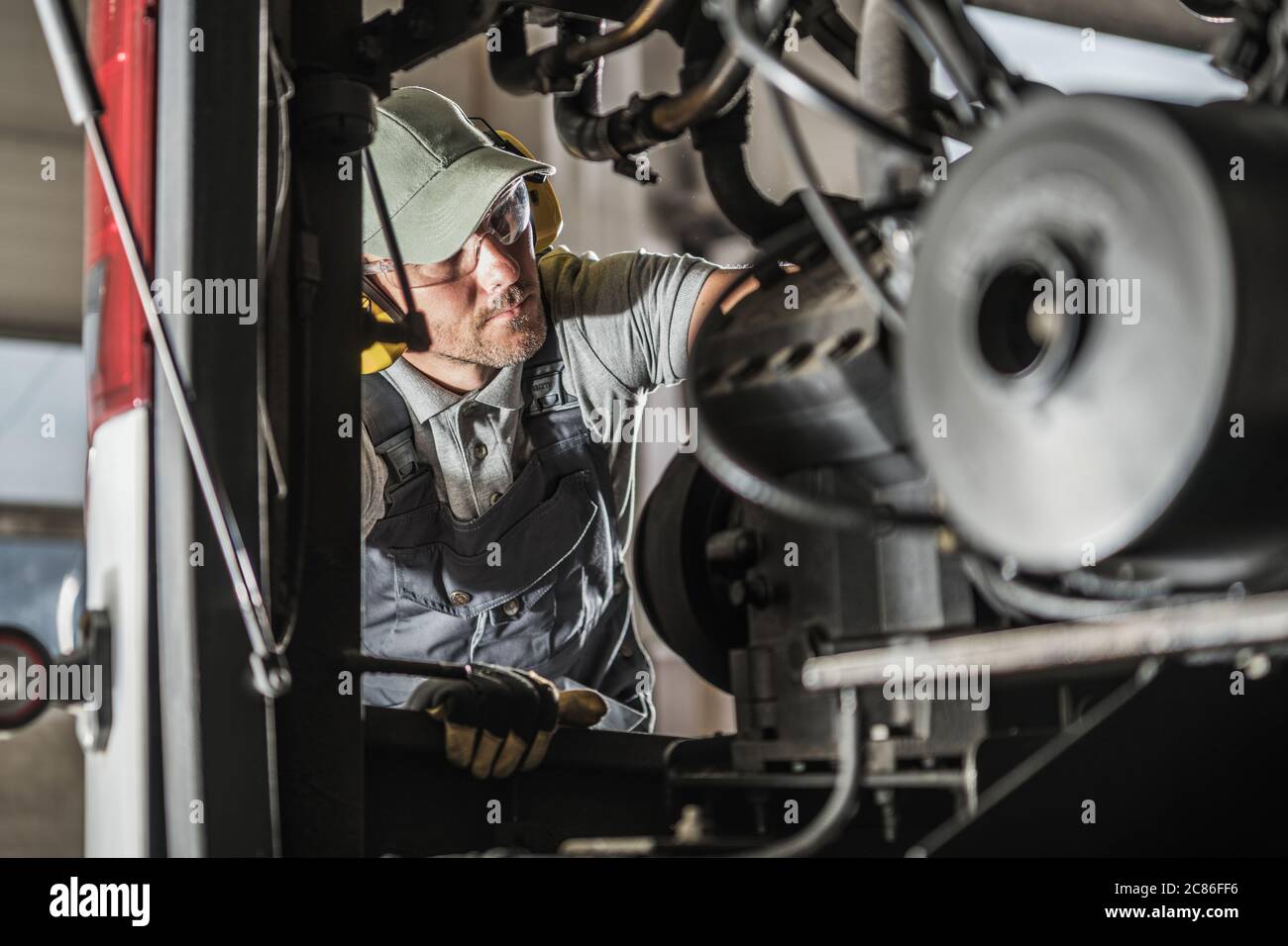 Automotive Caucasian Mechanic Performing Scheduled Diesel Truck or Bus ...