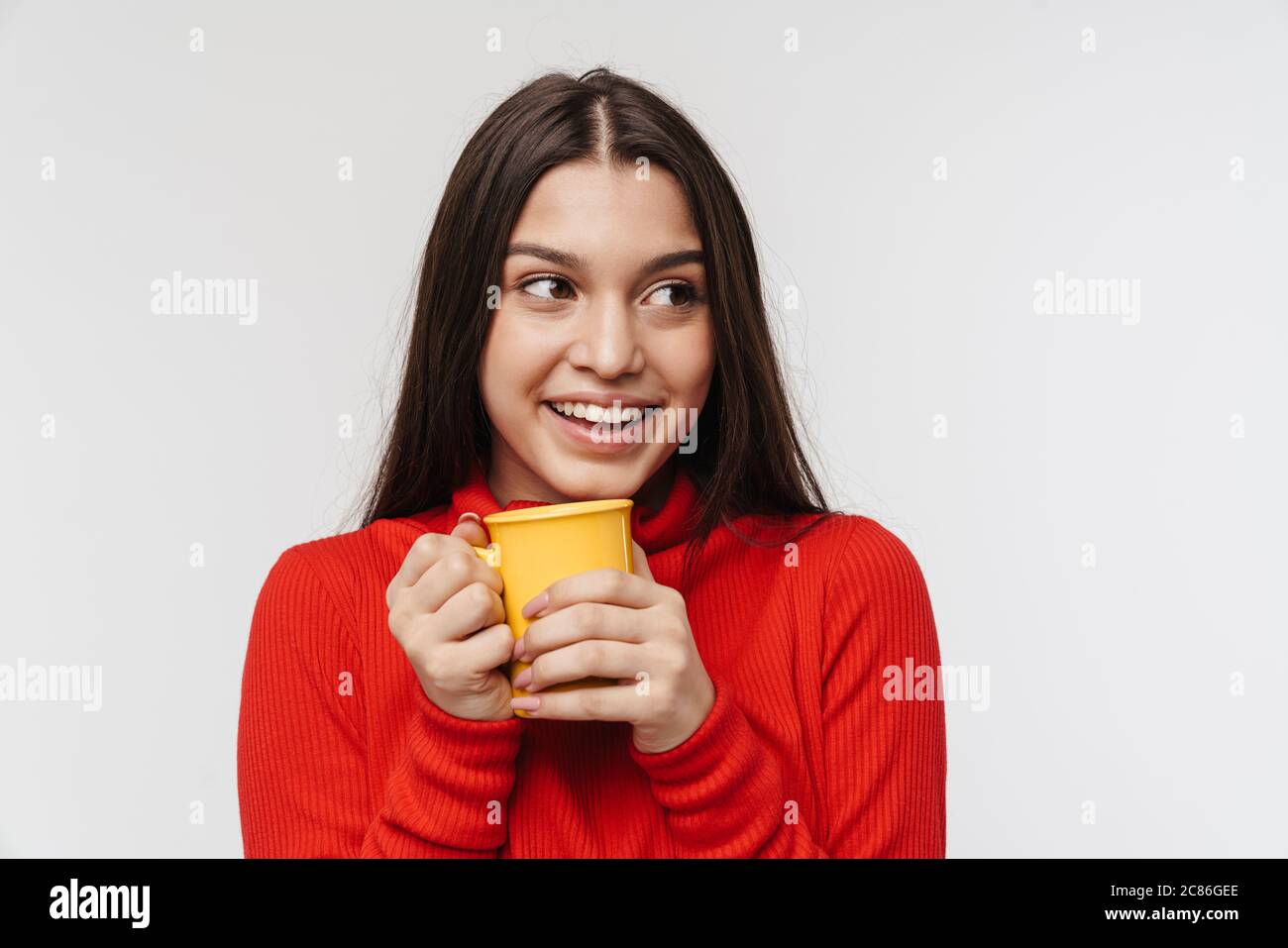 Photo of cheerful brunette woman laughing and holding cup isolated over ...