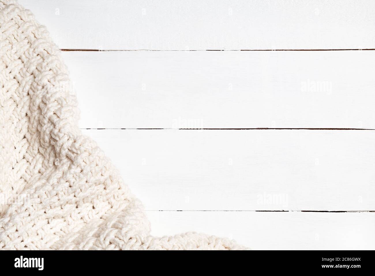 Warm light beige wool fabric on a white wooden background with copy ...