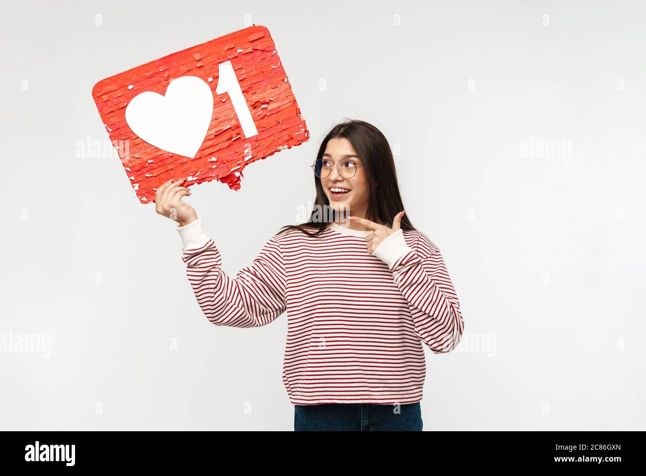 Photo of happy brunette young woman smiling and holding like symbol ...