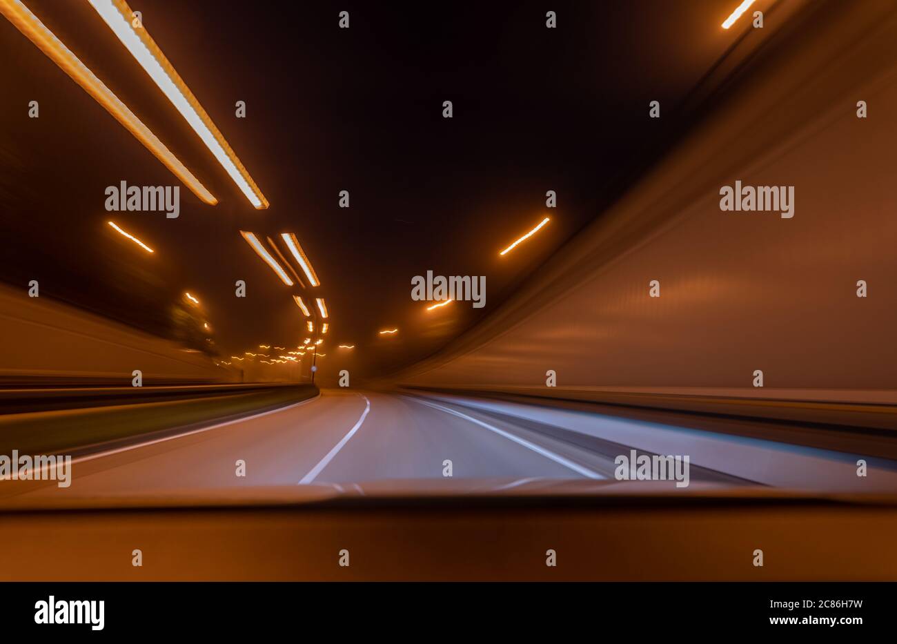 Fast drive through a tunnel with the view through the front window of a ...