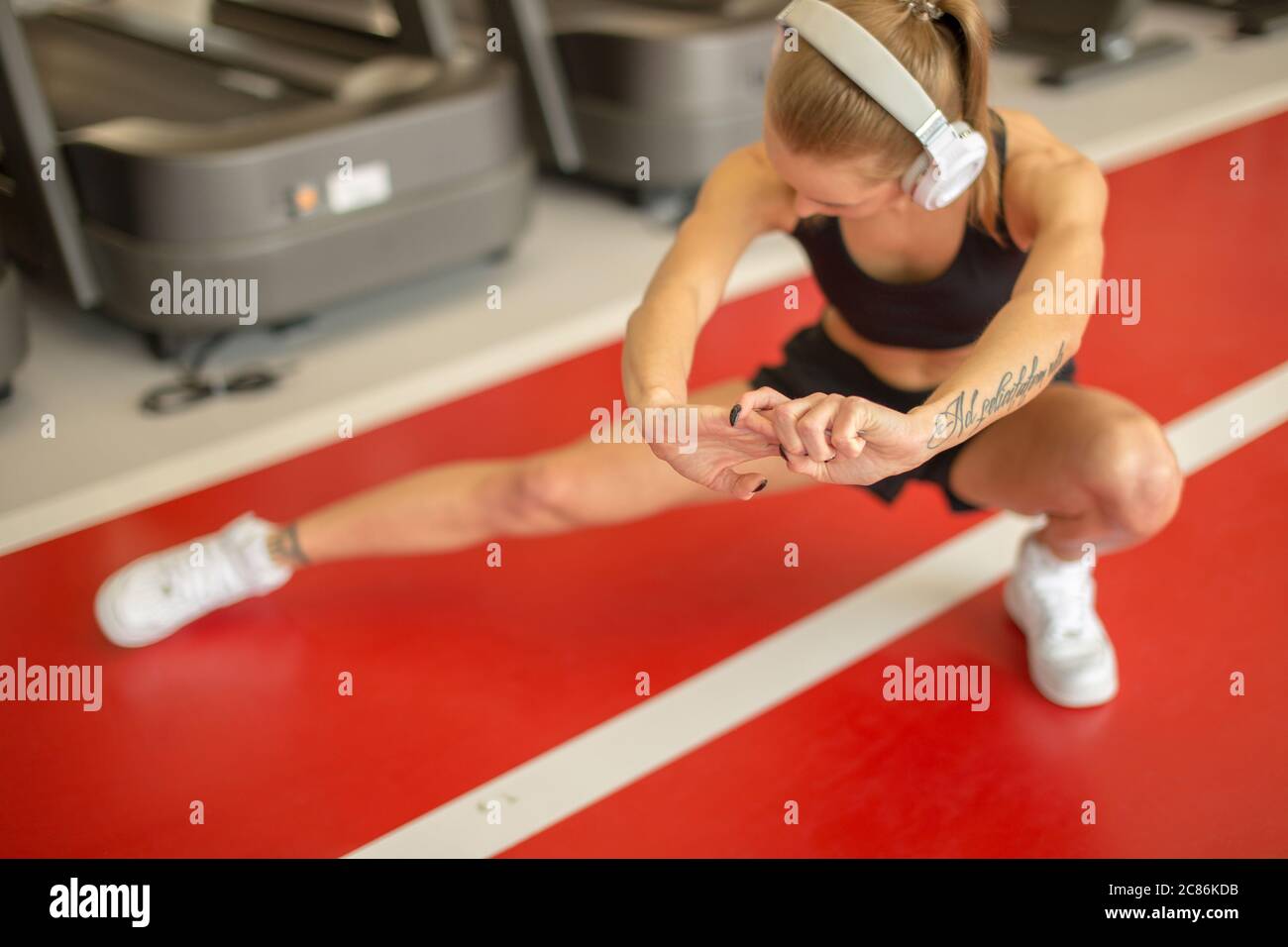 runner woman stretching leg muscle preparing for run on track. Female ...