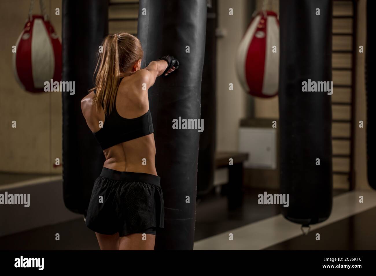 blond woman with boxing gloves, standing in position, ready to fight ...