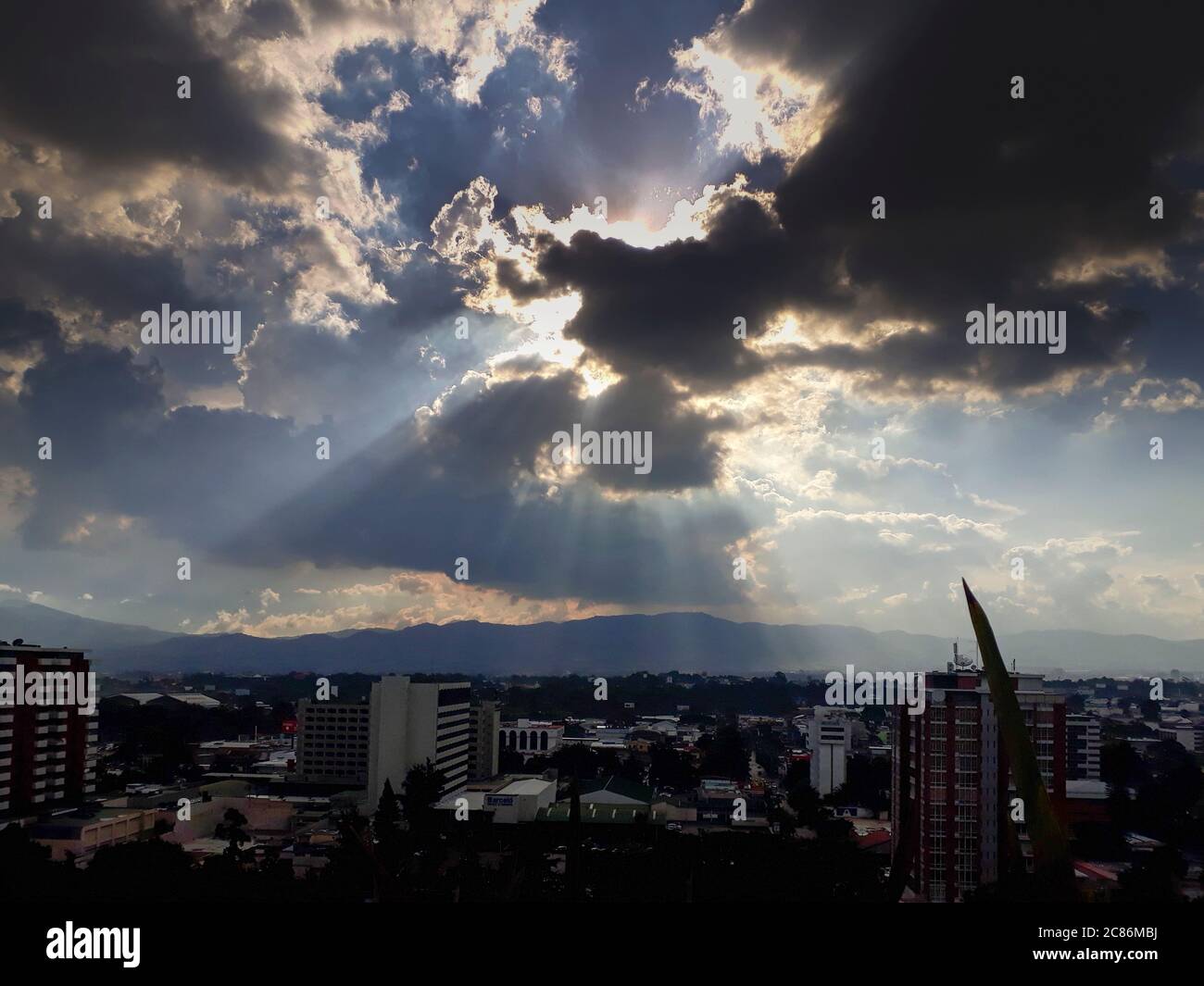 Sunset silhouettes in Guatemala City, view from terrace in capital city ...