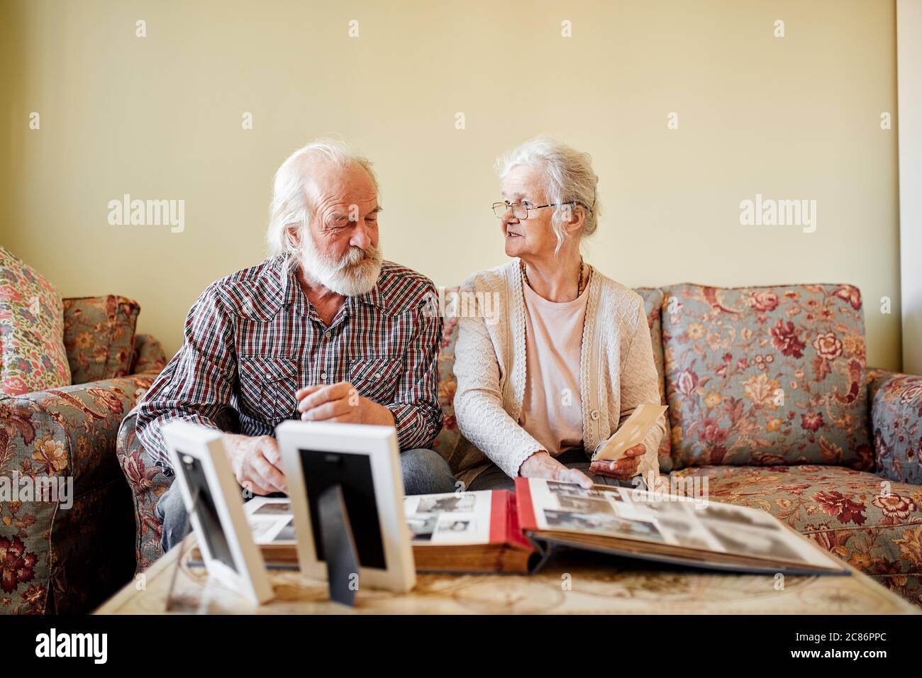 Senior european couple of pensioners sitting in cozy living room ...