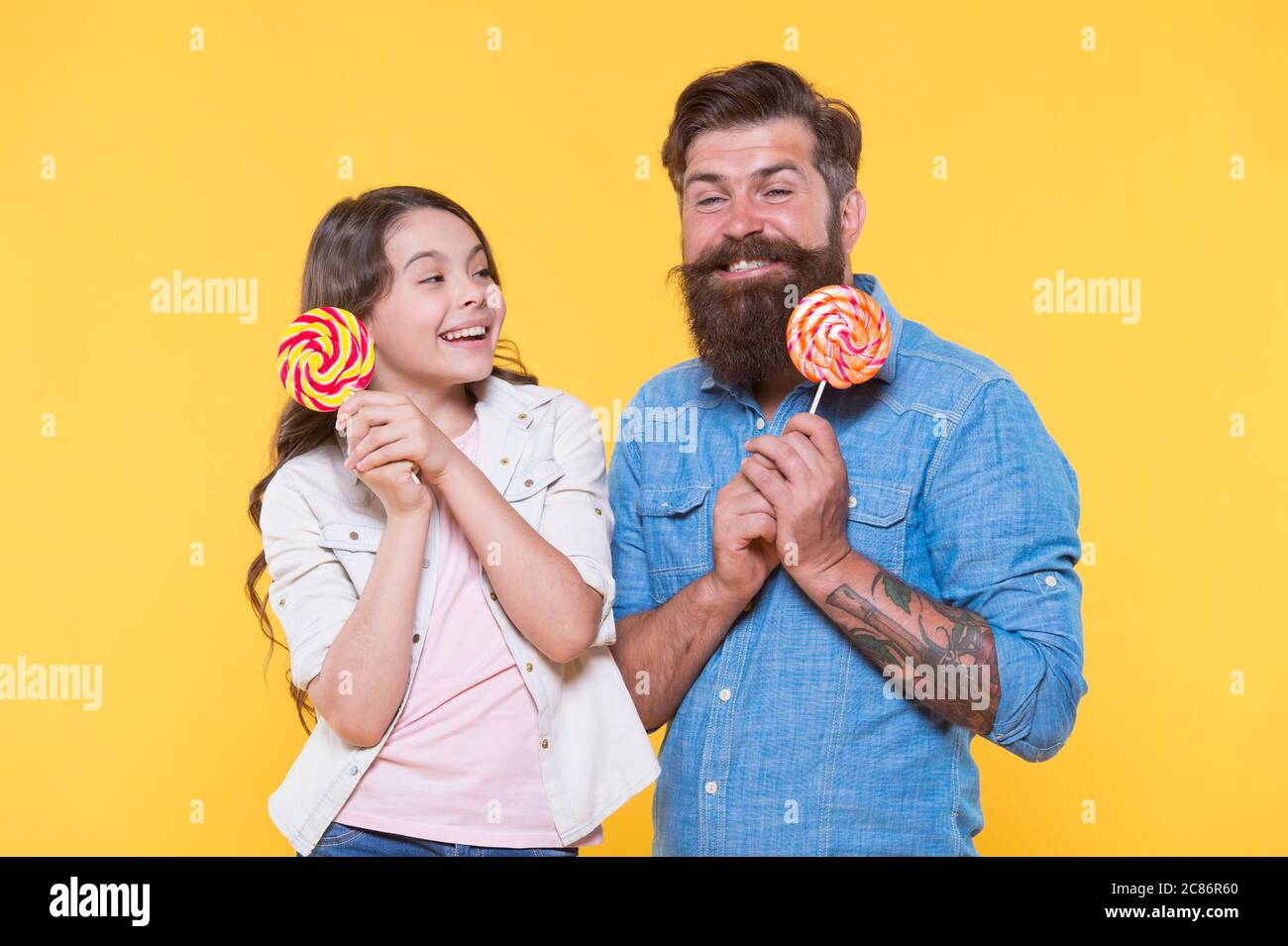 Never too delicious. Happy family hold lollipops yellow background ...