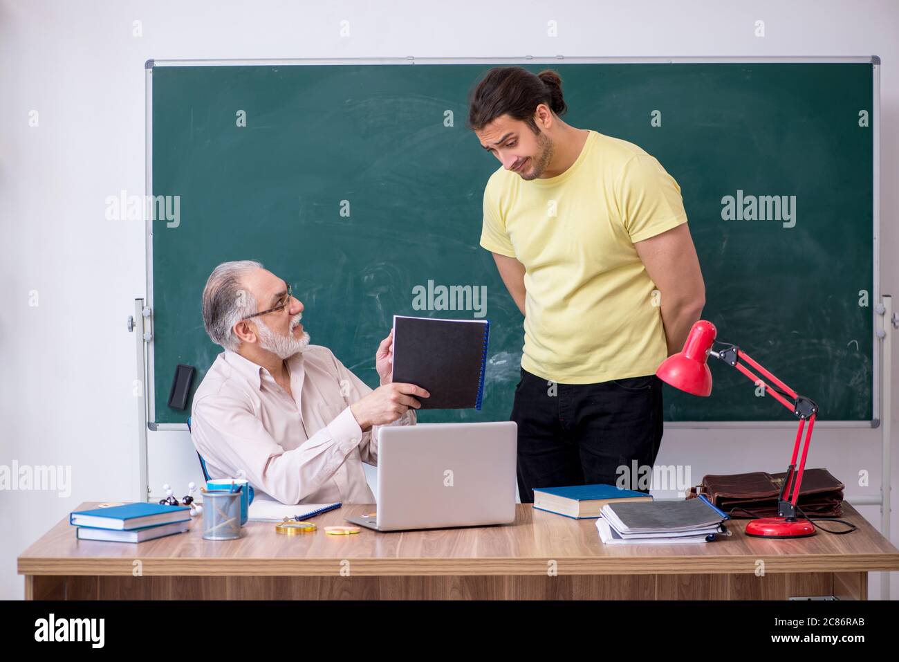 Old teacher and young student in the classroom Stock Photo - Alamy