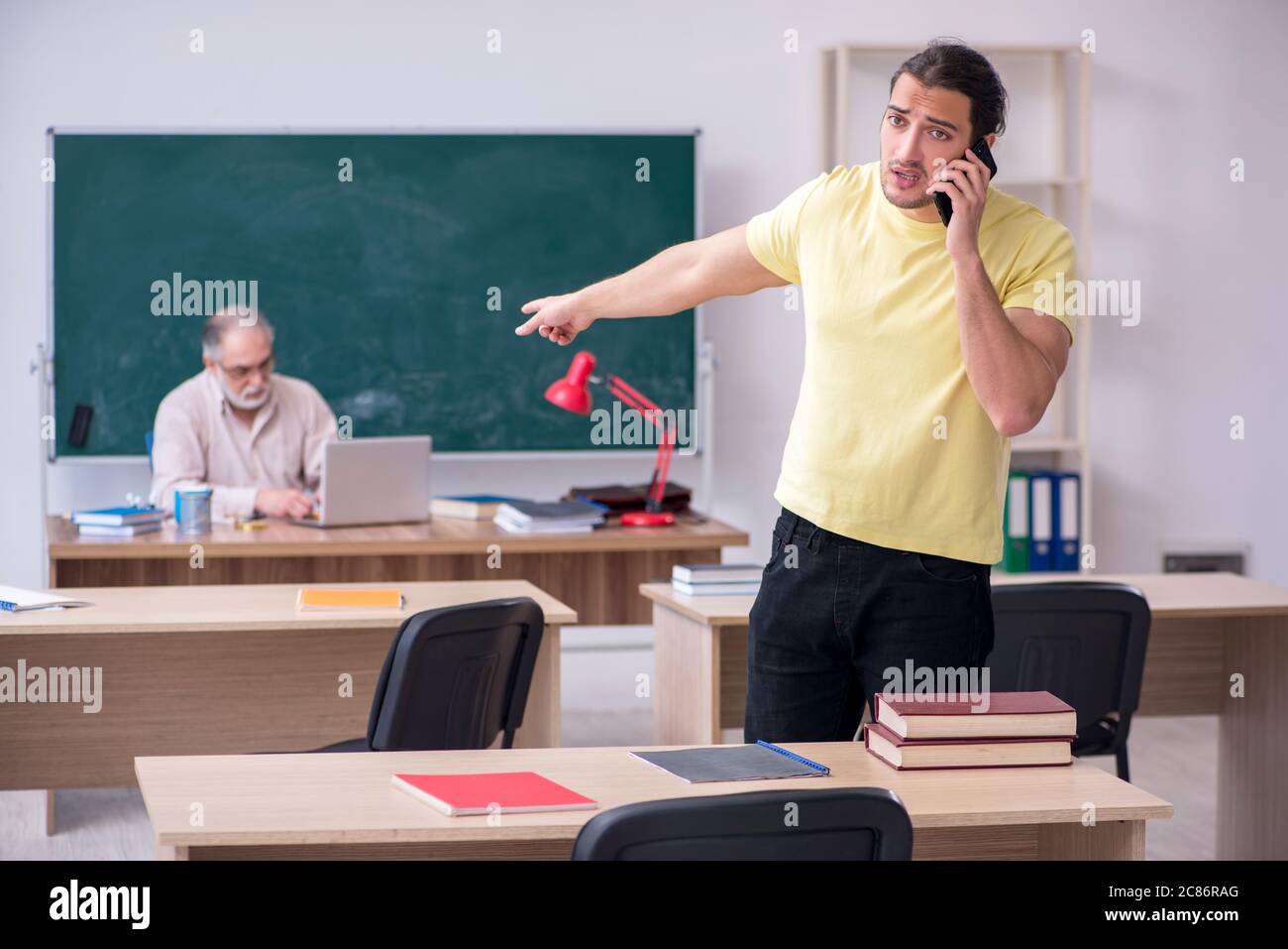 Old teacher and young student in the classroom Stock Photo - Alamy