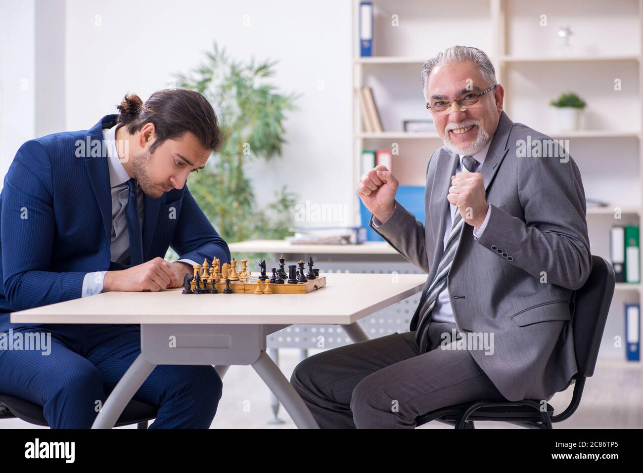 The two businessmen playing chess in the office Stock Photo - Alamy