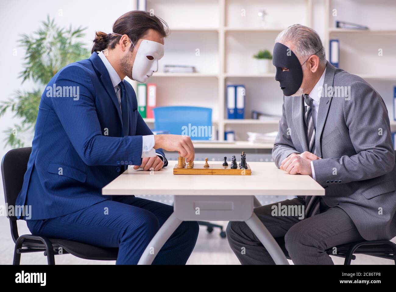 The two businessmen playing chess wearing masks Stock Photo - Alamy