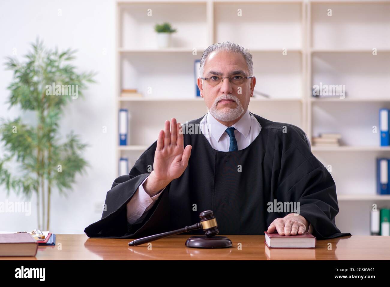 Old male judge working in the courthouse Stock Photo - Alamy