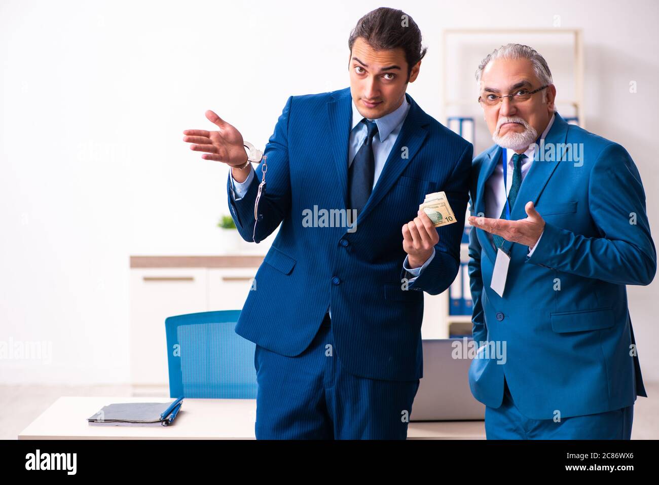 Male employee and cop in police investigation Stock Photo - Alamy