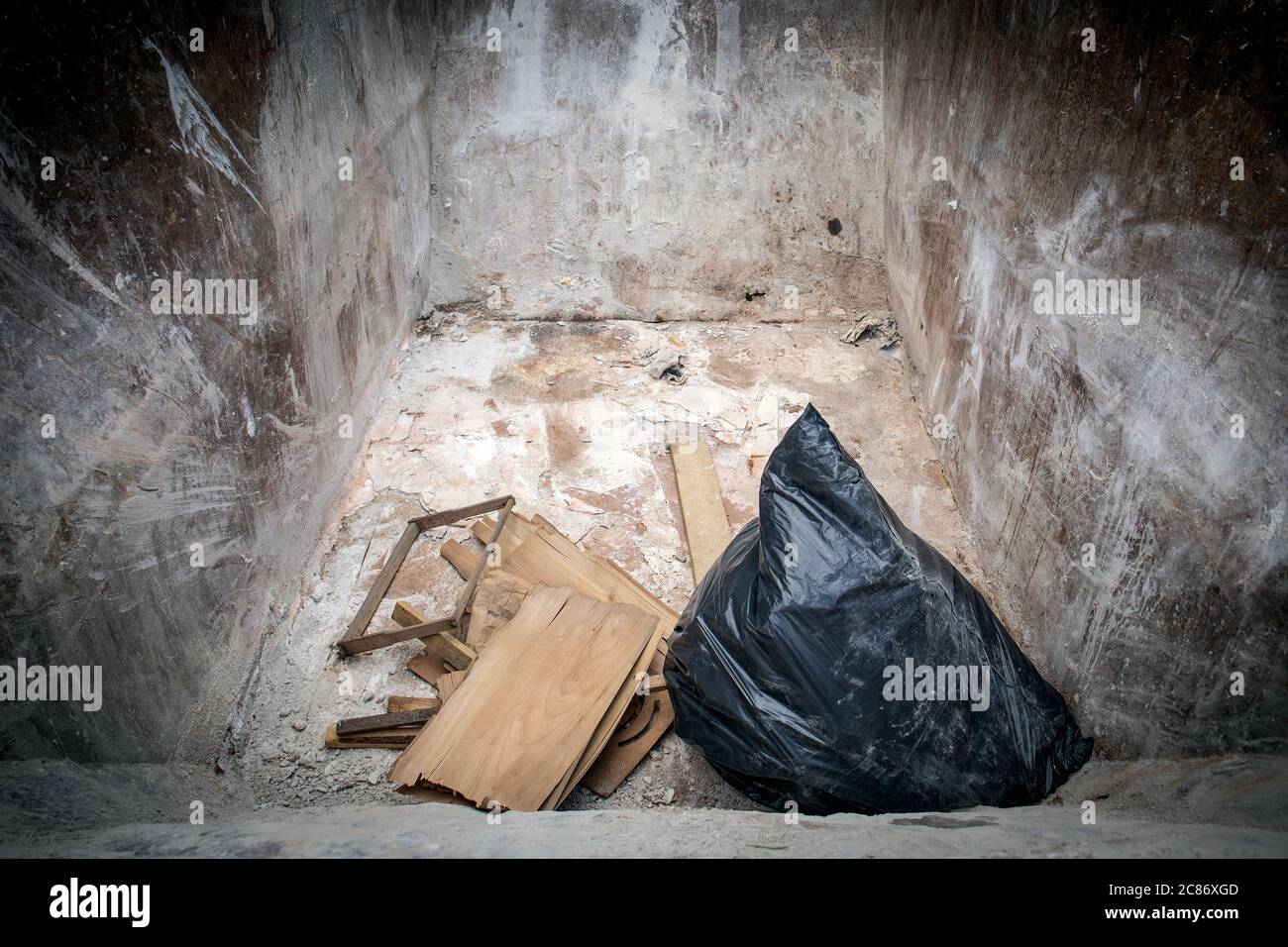 Wooden debris and black garbage bag in in waste container. Geting rid ...