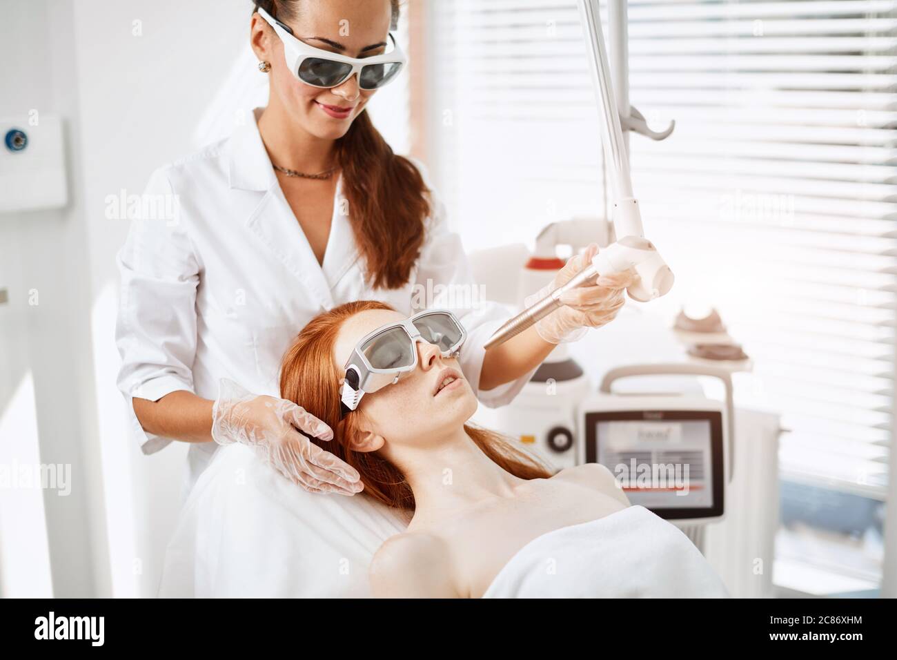 Ginger haied girl undergoes a procedure of laser rejuvenation at luxury ...