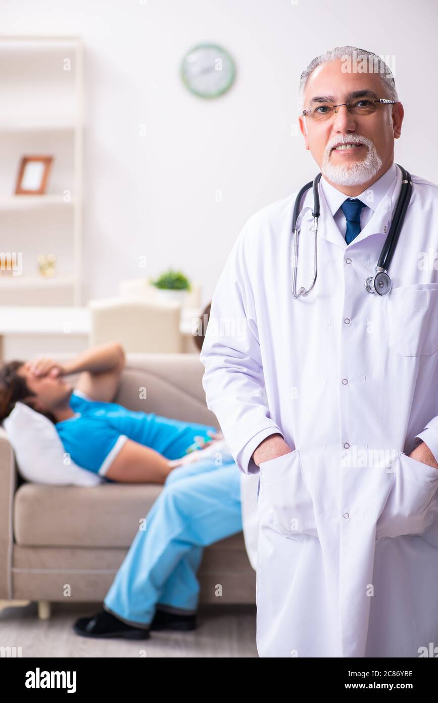 Two doctors visiting sick man at home Stock Photo - Alamy