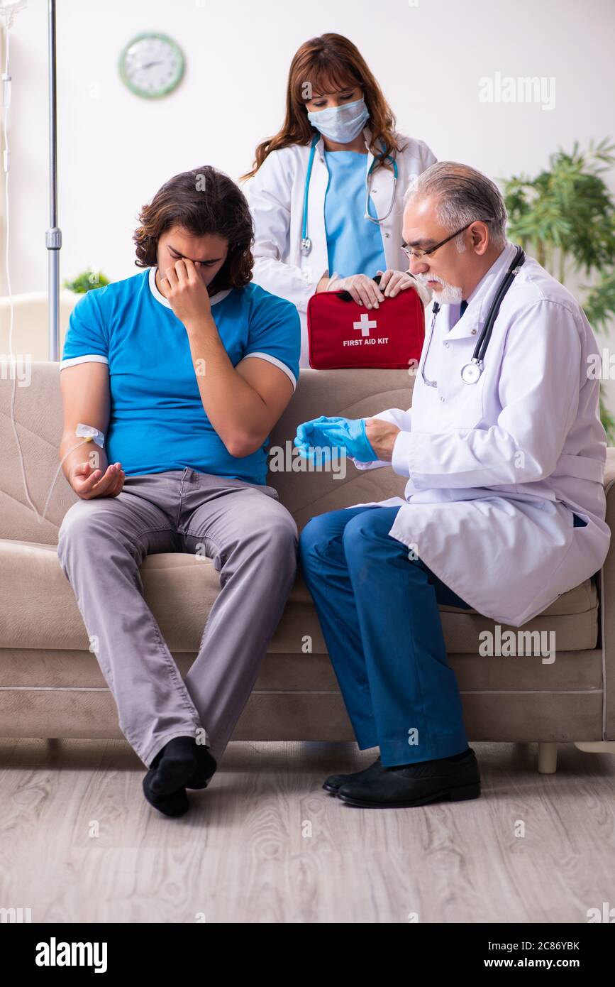 Two doctors visiting sick man at home Stock Photo - Alamy