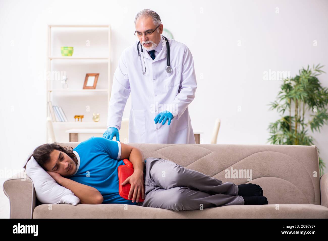 Two doctors visiting sick man at home Stock Photo - Alamy