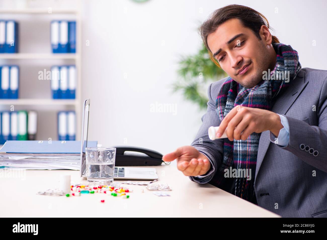 Young employee suffering at workplace Stock Photo - Alamy