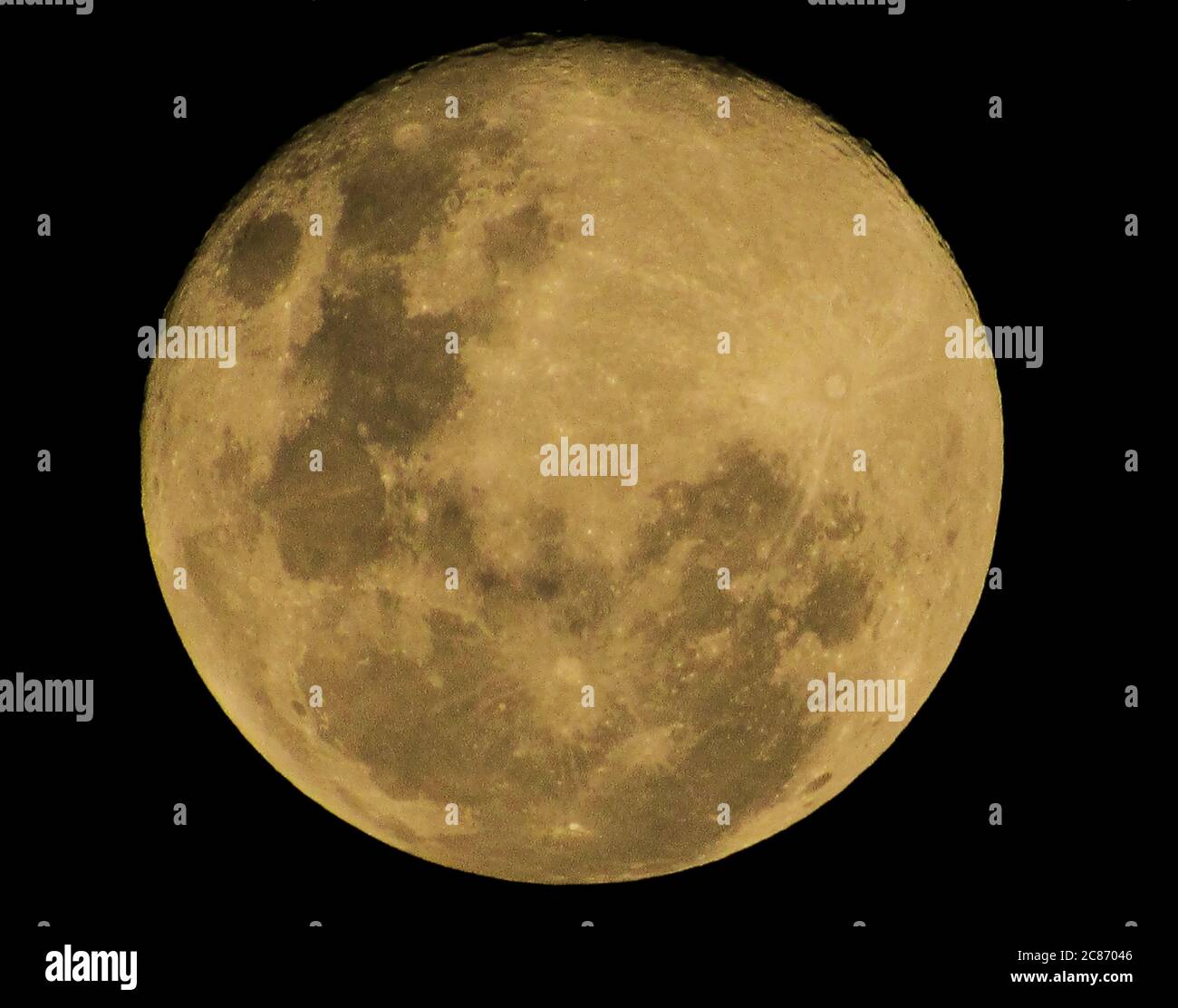 Large golden moon with golden tones, observed at night in the southern ...