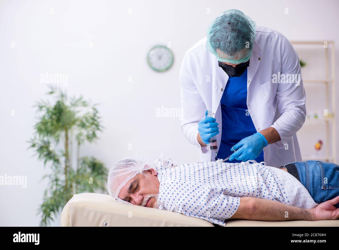 Old man visiting young intern doctor Stock Photo - Alamy