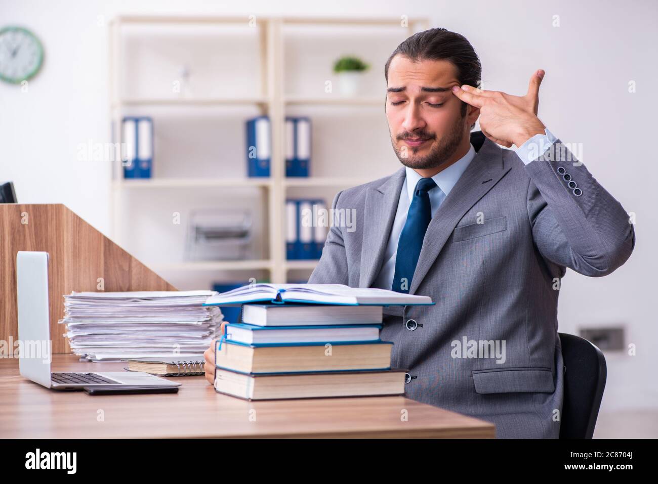 Young businessman reading books at workplace Stock Photo - Alamy