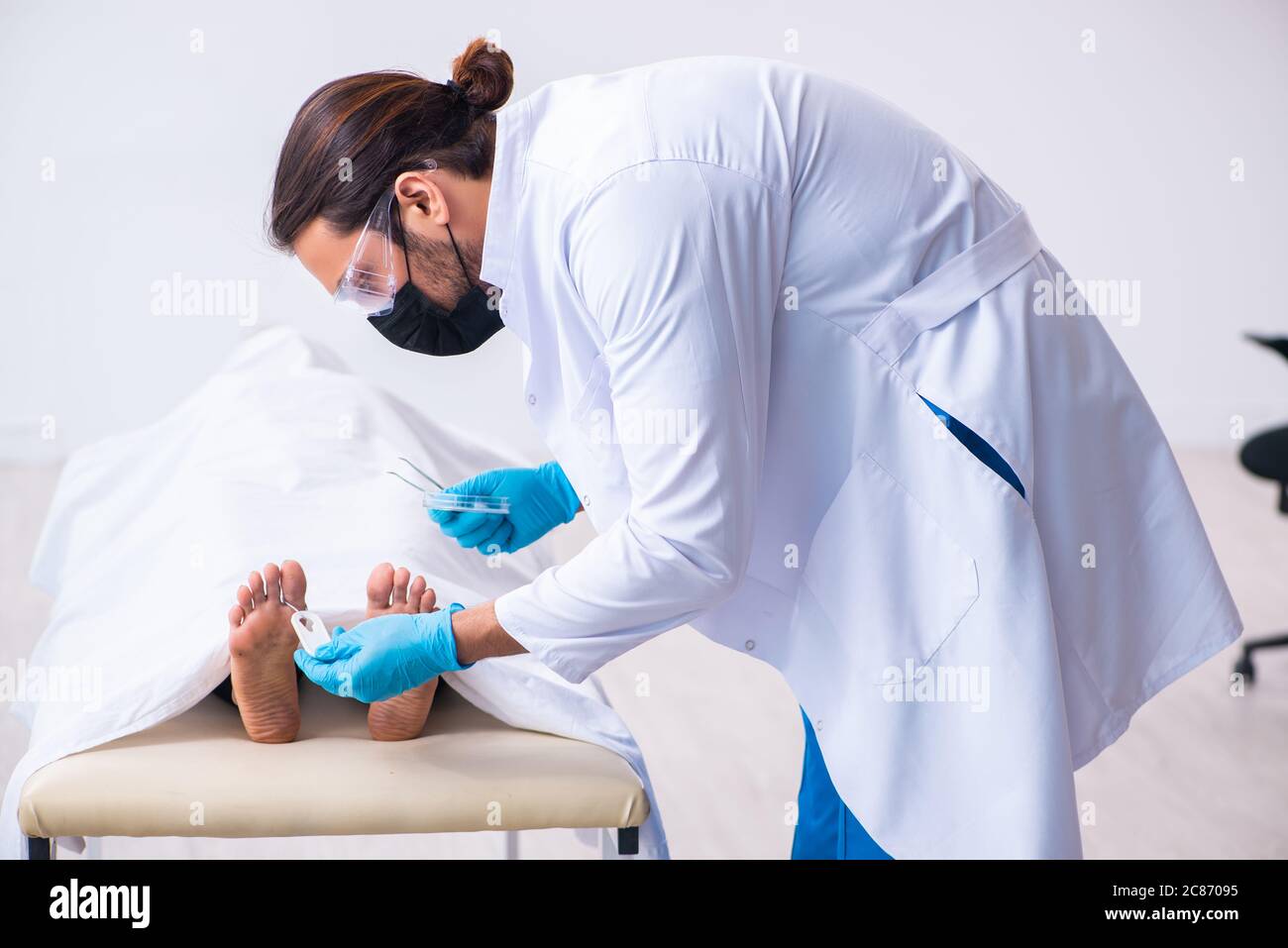 Police coroner examining dead body in morgue Stock Photo - Alamy