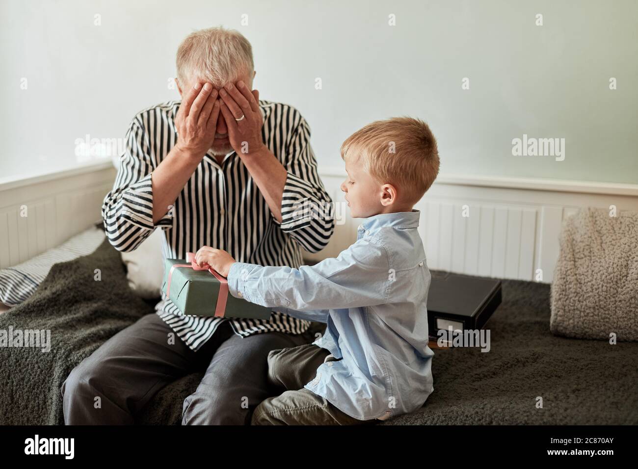 Grandson is giving present to his grandfather in living room Stock ...