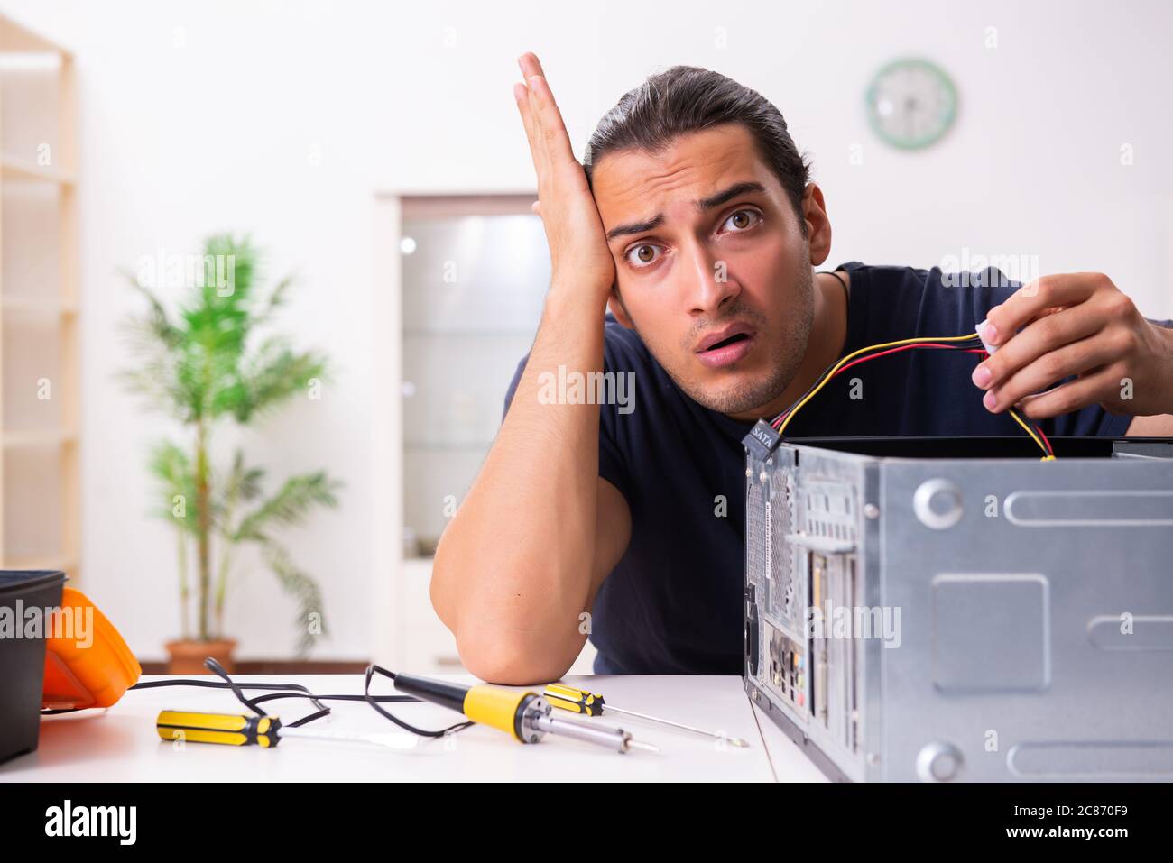 Young man repairing computer at the home Stock Photo - Alamy