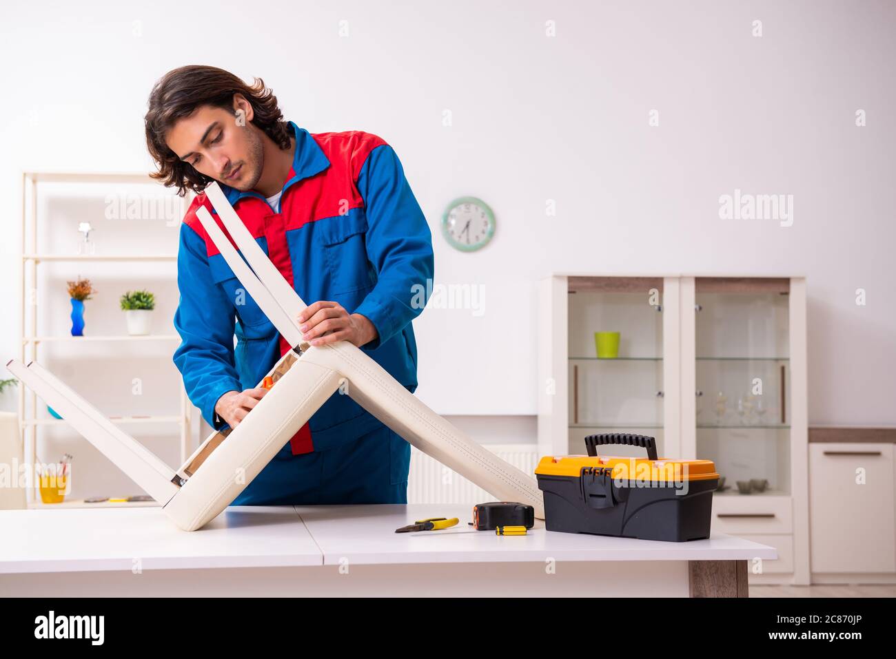 Young carpenter working assembling furniture Stock Photo - Alamy