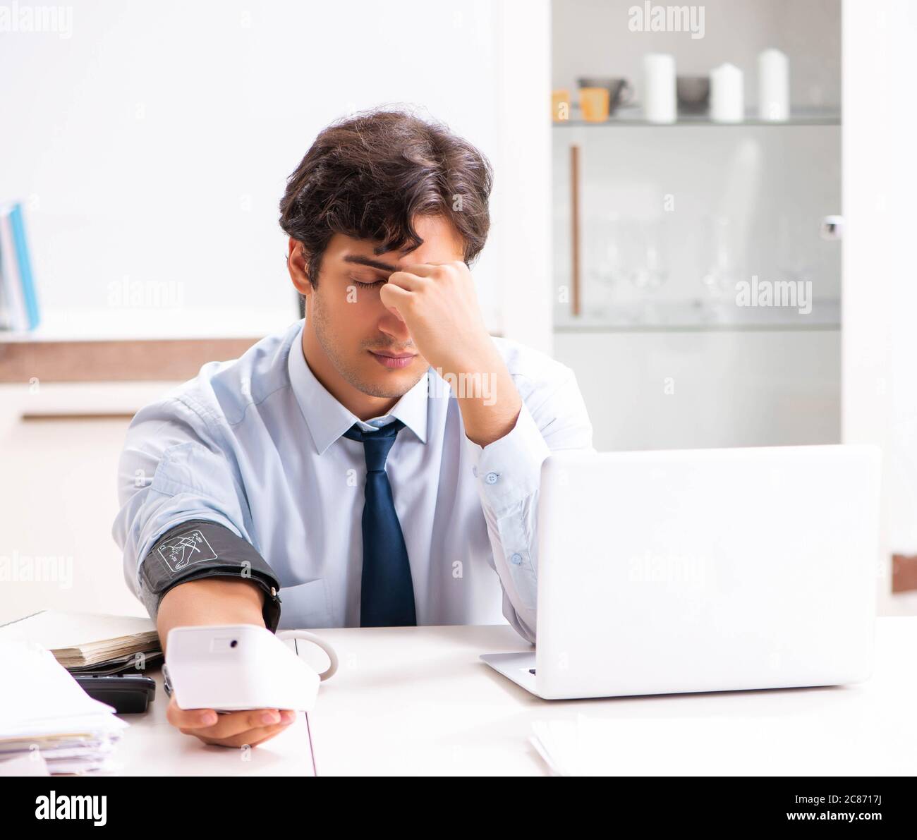 The man under stress measuring his blood pressure Stock Photo - Alamy