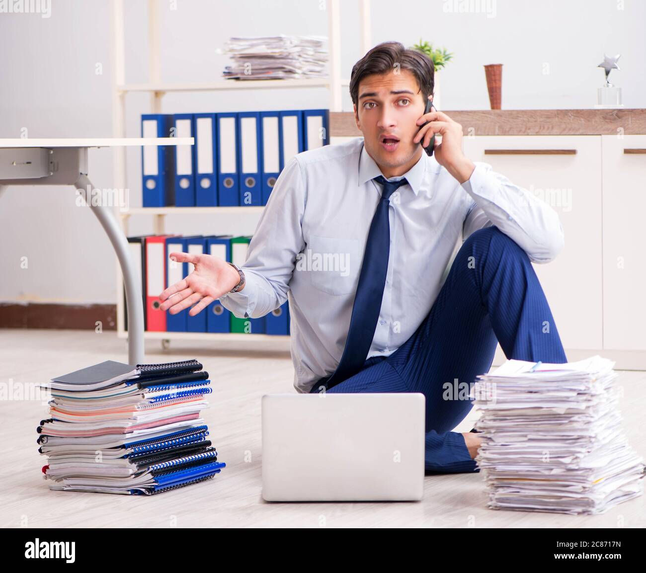 The extremely busy employee working in the office Stock Photo - Alamy